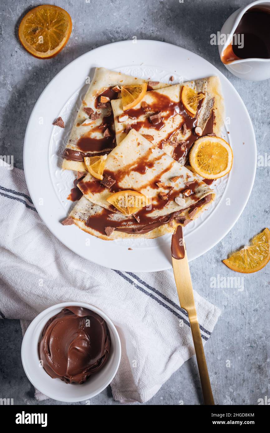 Crepes pancakes formed in pyramid shape on a blue plate in bright ...