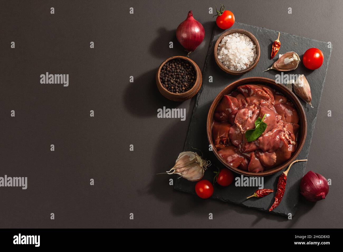 Raw chicken liver in a ceramic bowl. Fresh food ingredient with spices ...