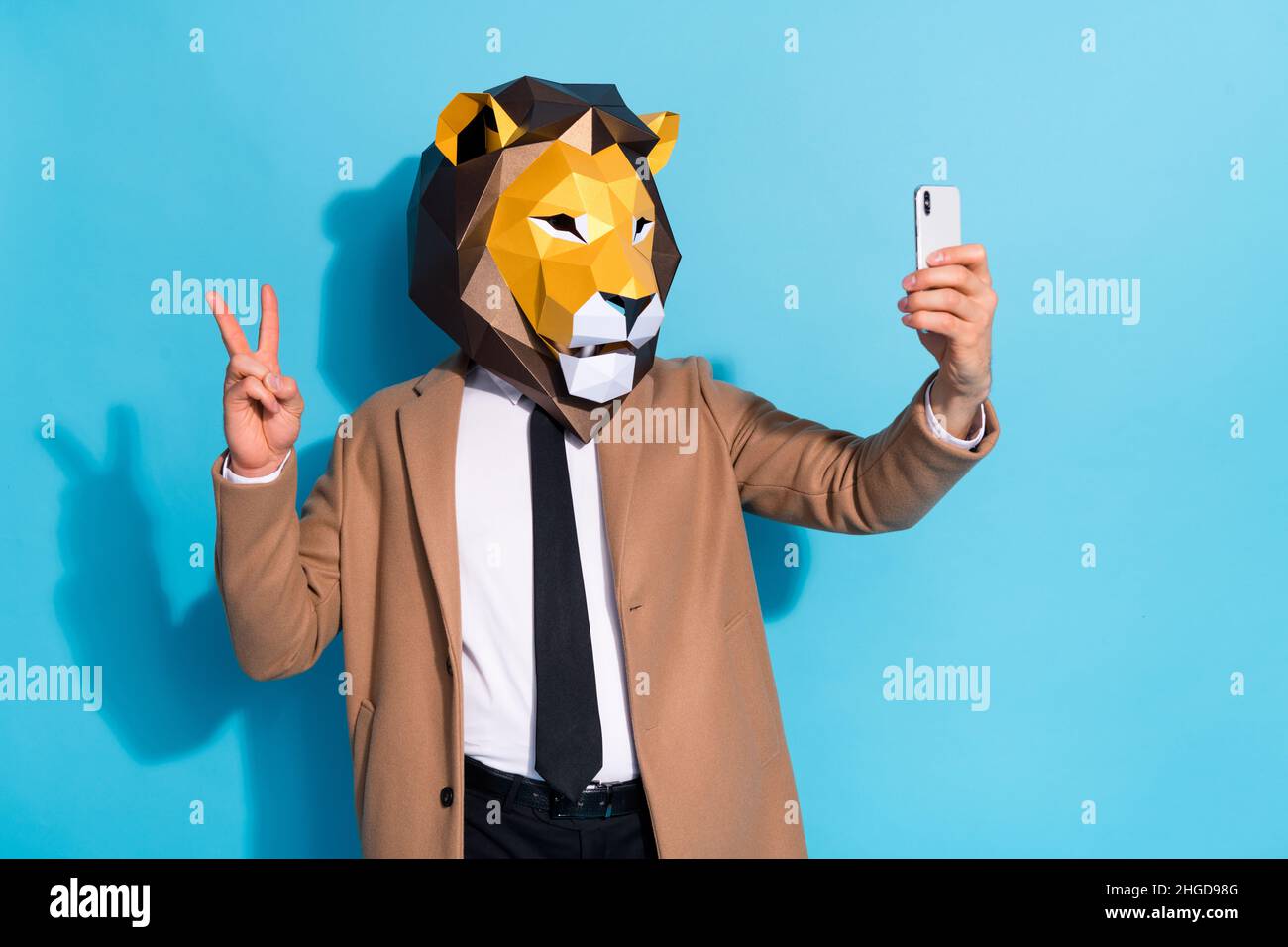 Photo of weird bizarre guy in lion mask taking selfie smart phone make ...