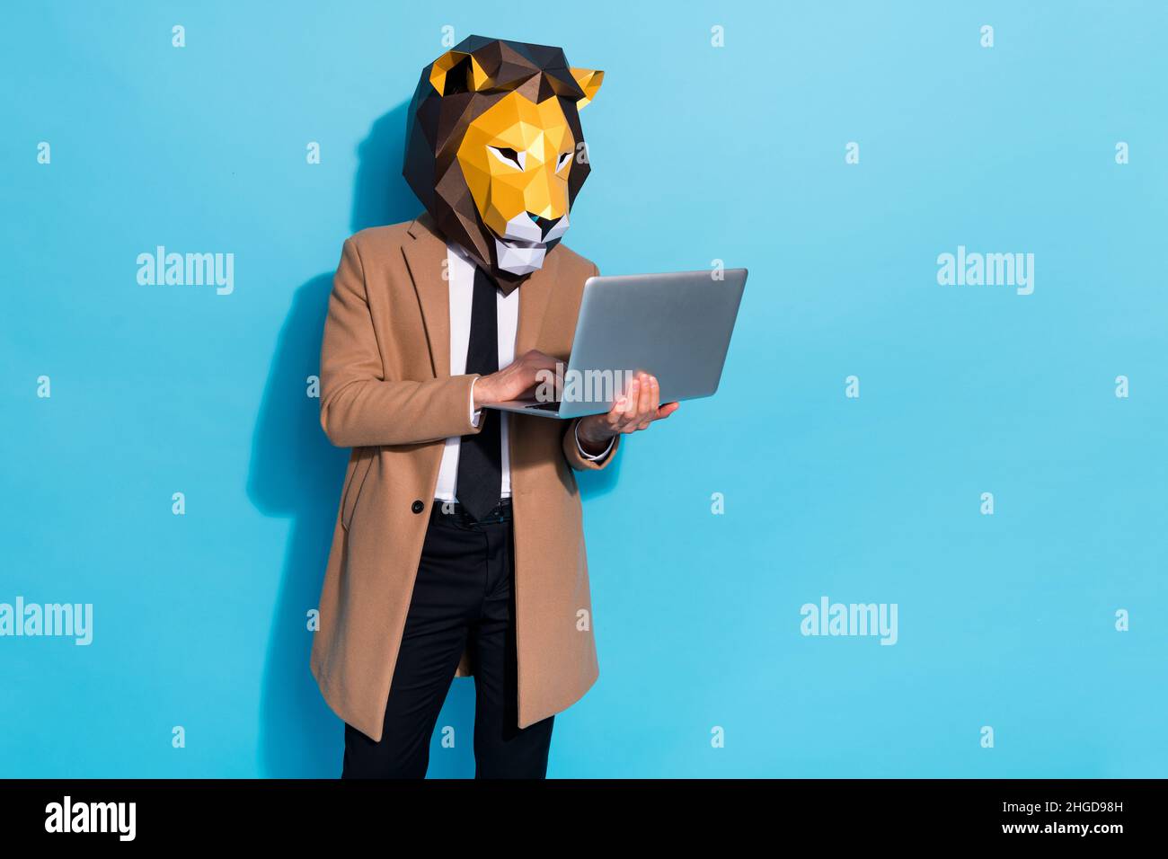Photo of focused manager guy in lion mask typing netbook app search report isolated over blue ...