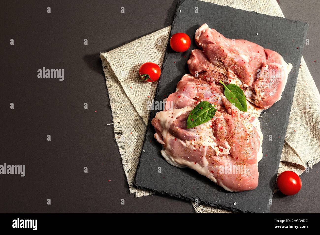 Raw turkey thigh with spices. Fresh boneless meat on a ceramic stand ...