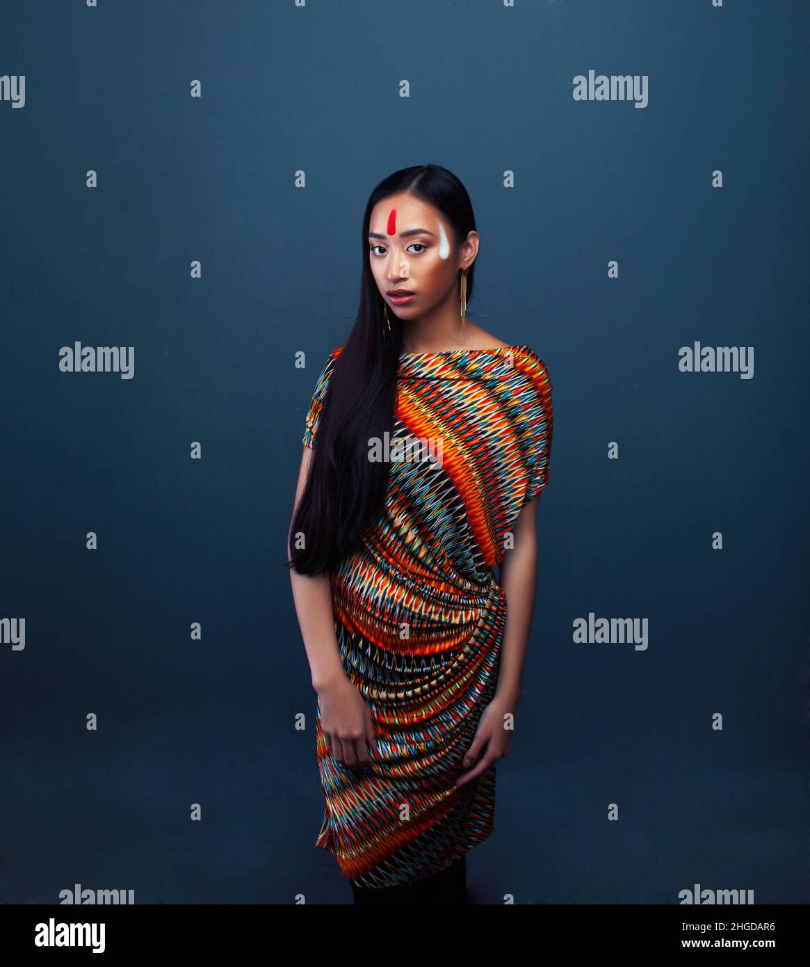 young pretty south asian girl posing in studio on grey background ...