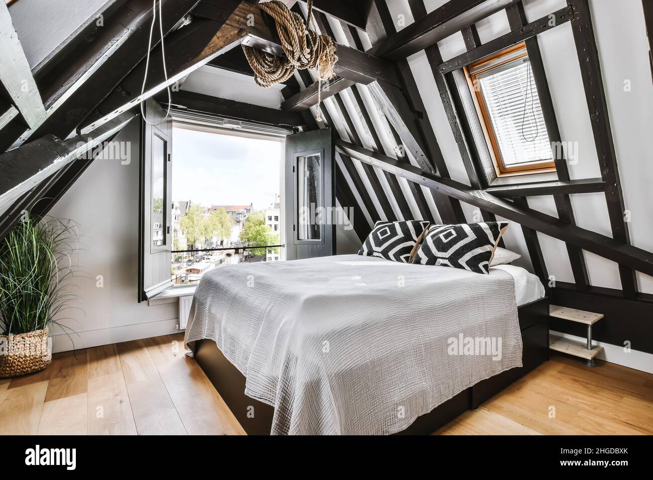 Stylish attic bedroom with wooden beams and a soft bed Stock Photo - Alamy