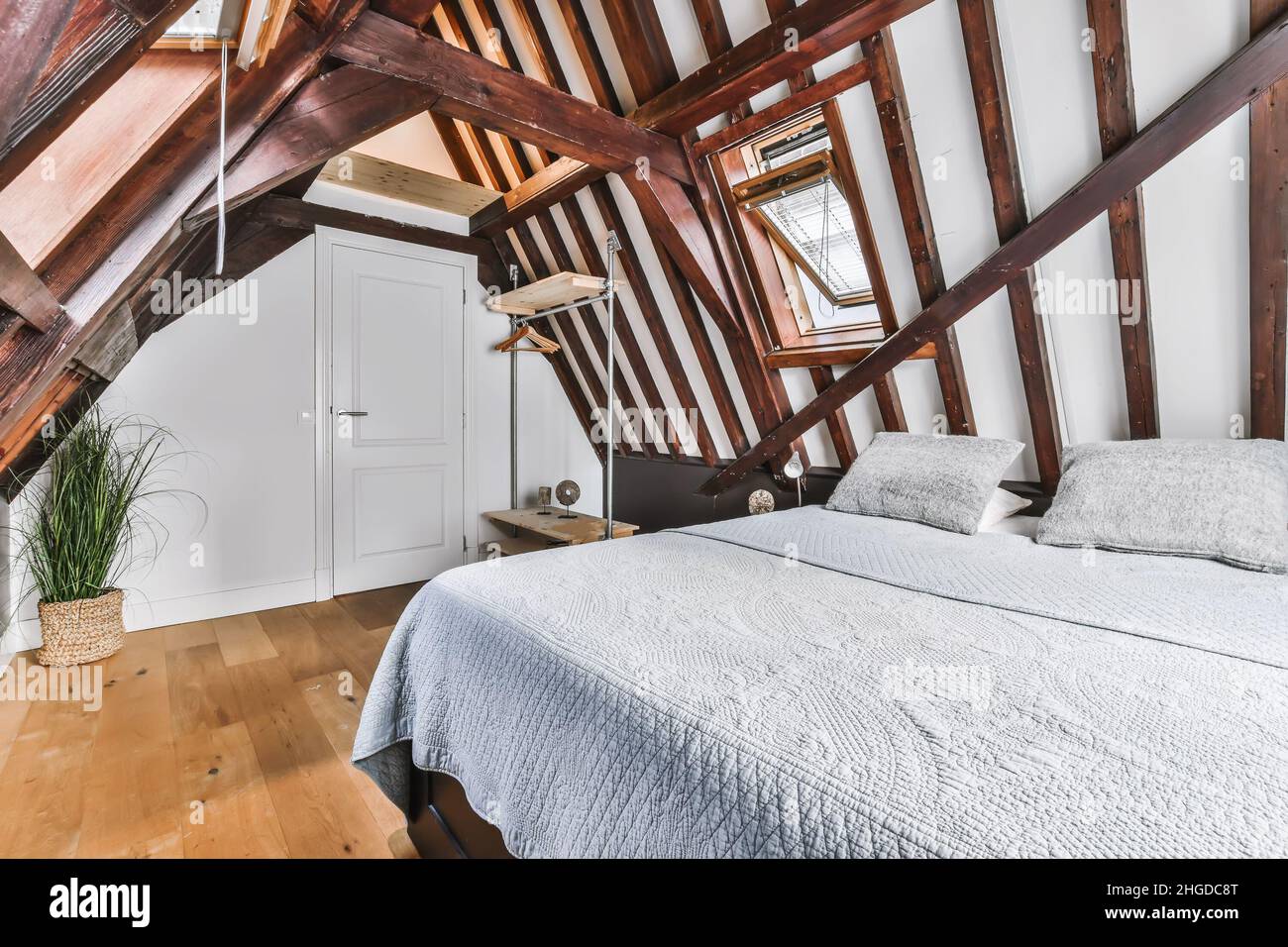 Stylish attic bedroom with wooden beams and a soft bed Stock Photo - Alamy