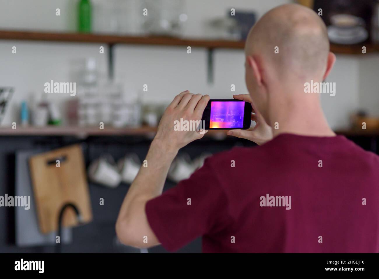 Person doing thermal scanning or imaging of apartment with smartphone ...