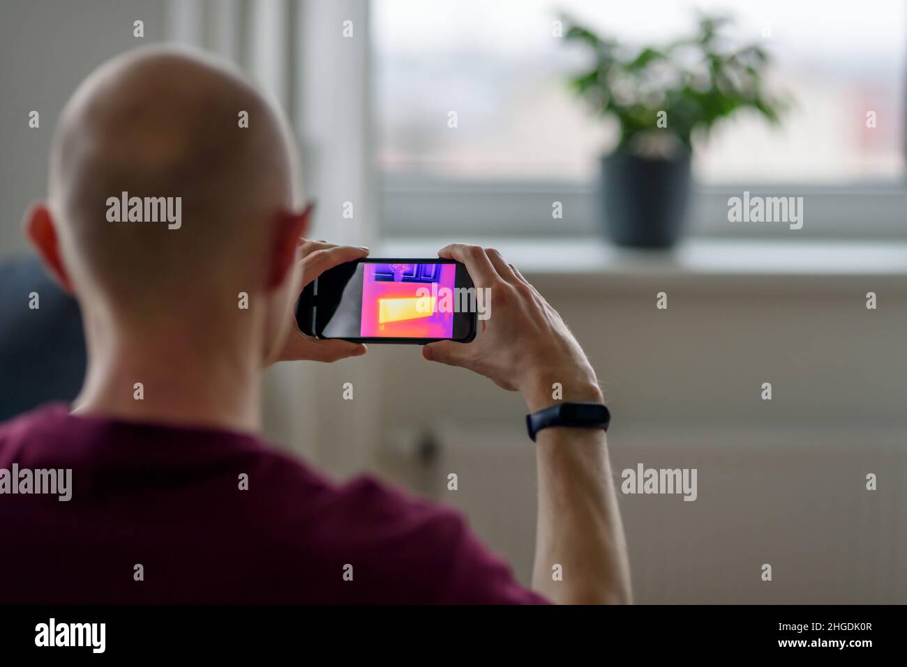Person doing thermal scanning or imaging of apartment with smartphone ...