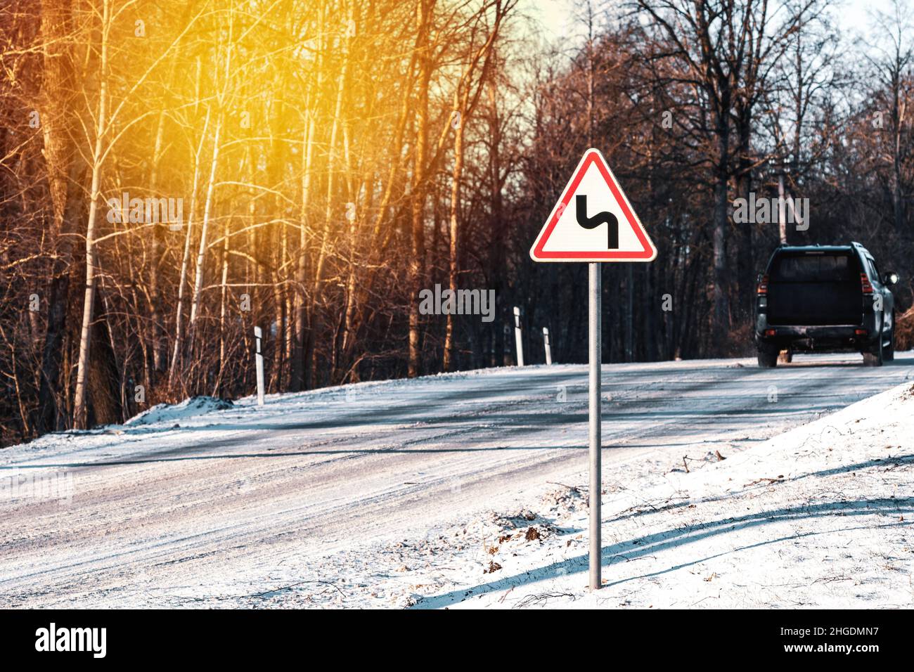 Driving on a winter road. Road sign on a snow-covered road with car in ...