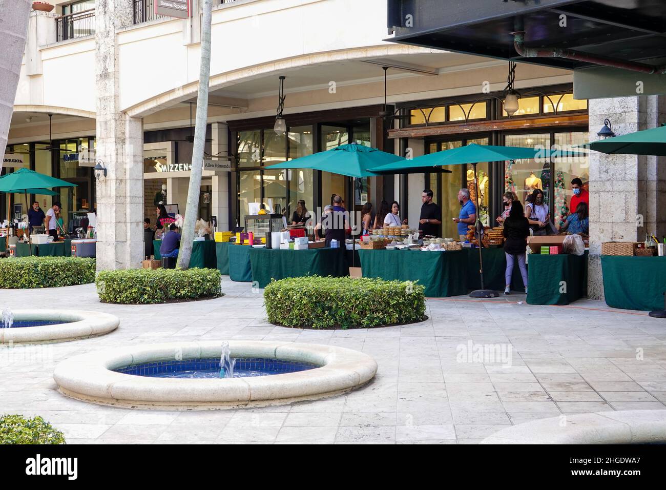 People shopping at booths set up in the outdoor open area of the Shops ...