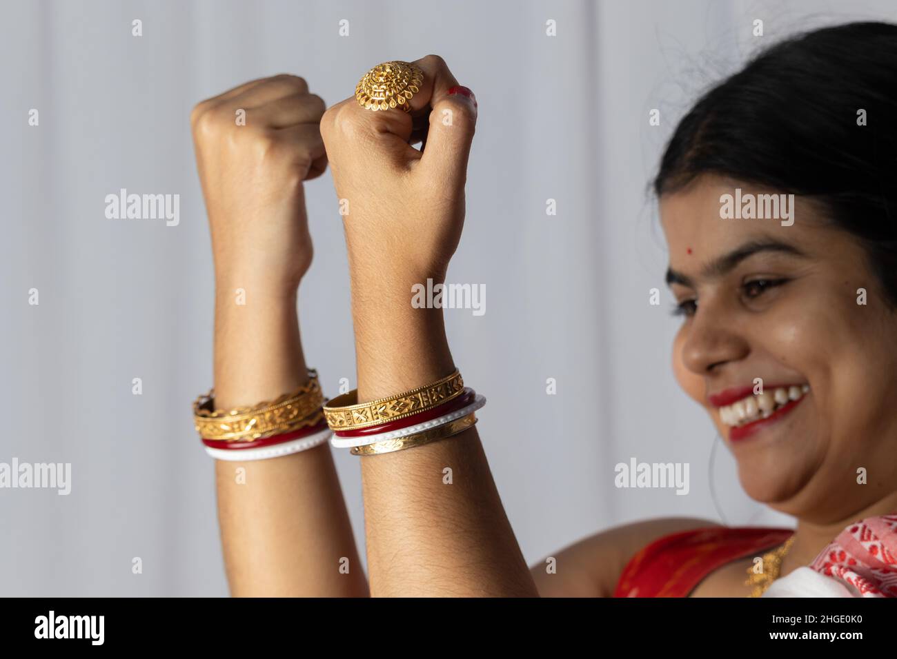 Selective focus on hands of an Indian woman in red saree wearing ...