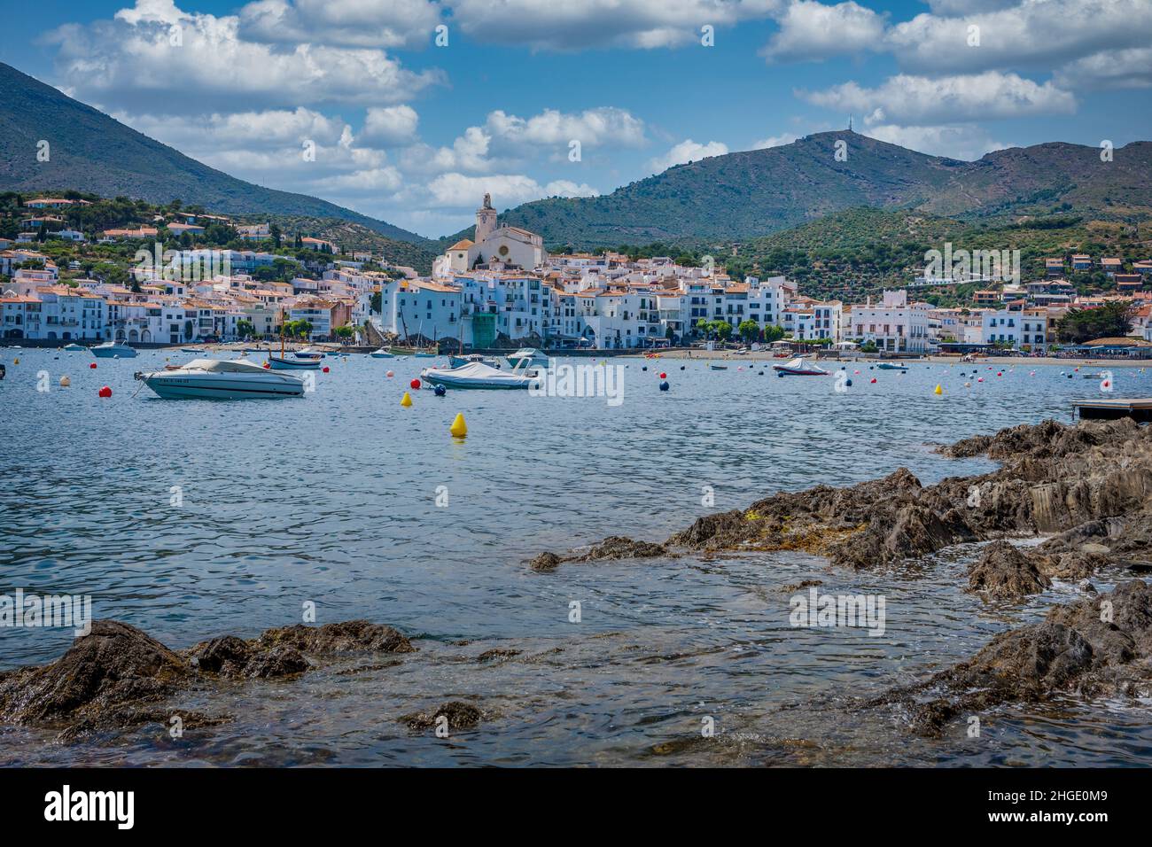 Spanish coastal village of Cadaques in the sunshine with motor boats ...