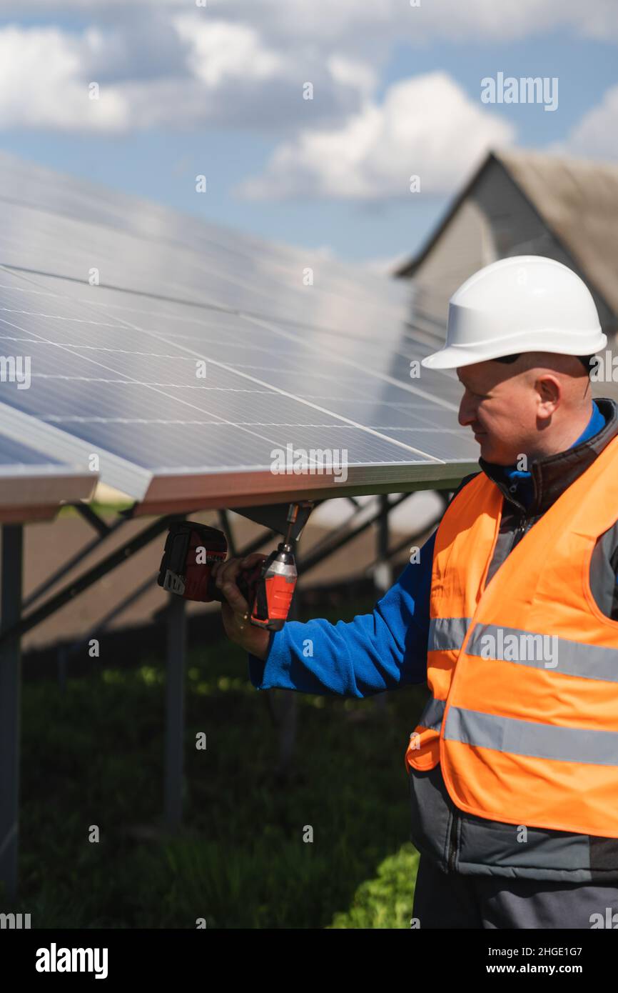 Engineer in a hard hat and reflective vest maintains solar panels Stock ...