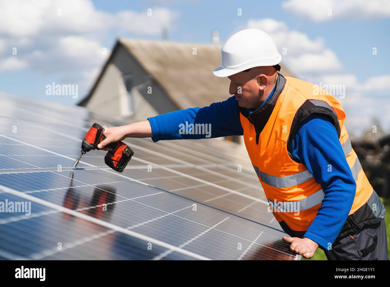 Man with drill screwdriver installs panels at a solar power plant Stock ...
