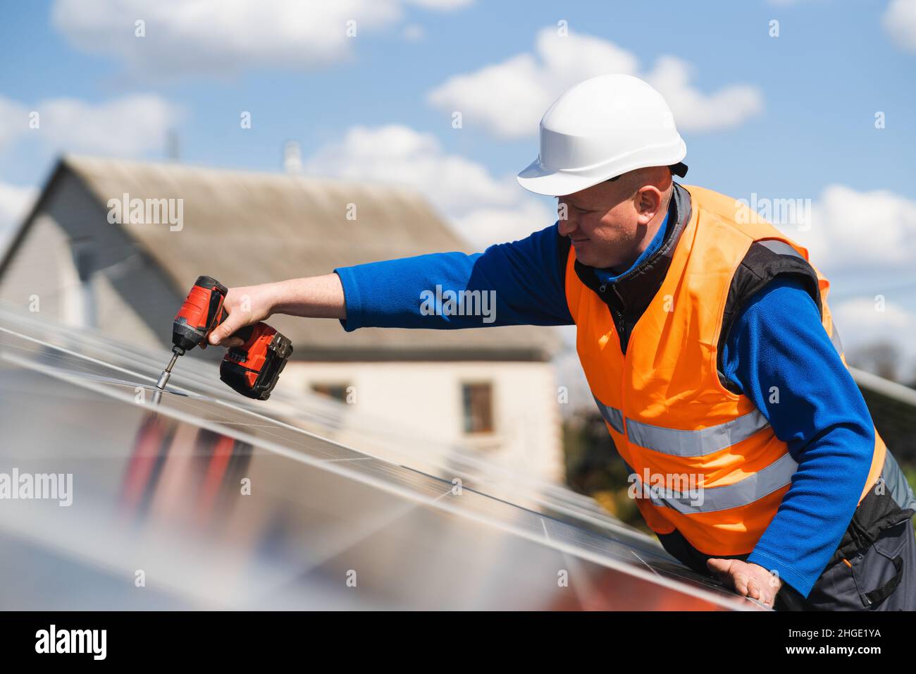 Man with drill screwdriver installs panels at a solar power plant Stock ...