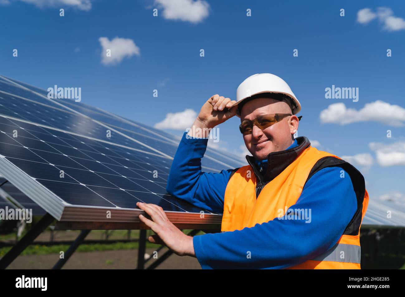 Portrait of a solar farm worker leaning against the panels Stock Photo ...
