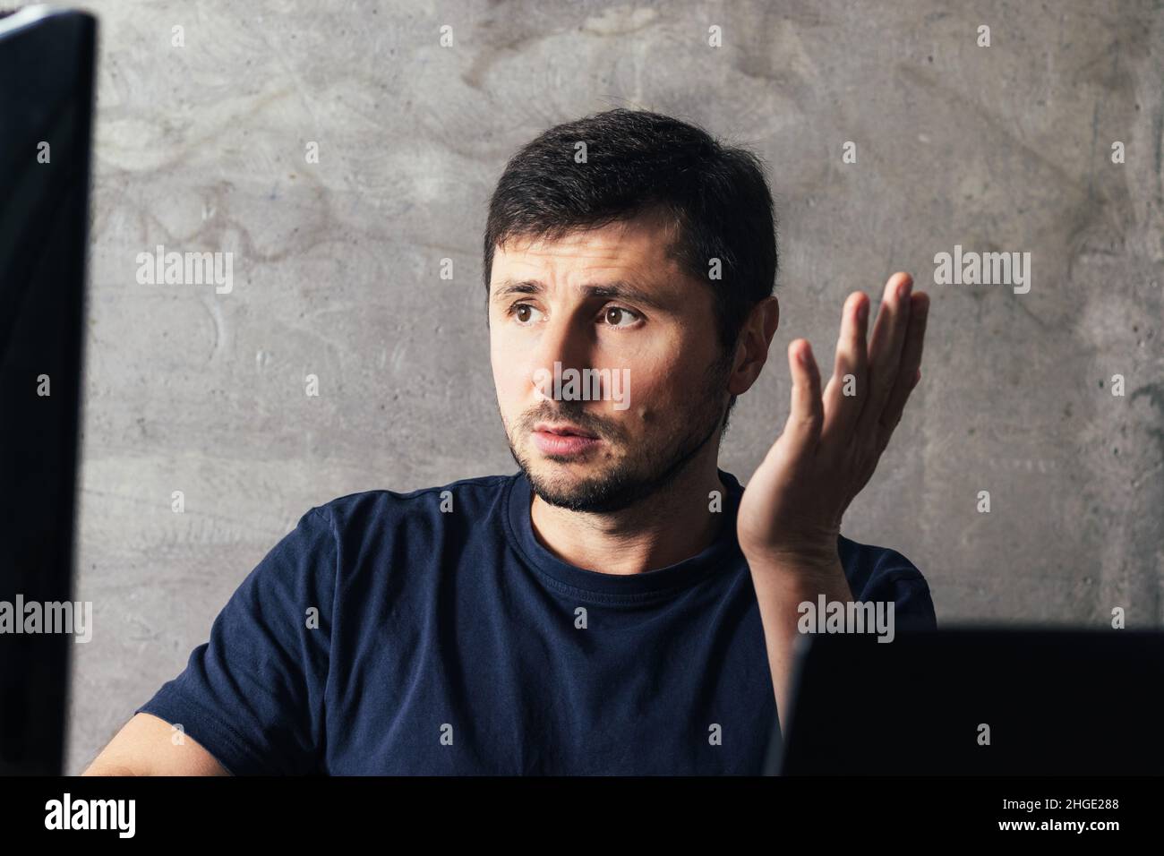 Handsome concentrated serious bearded man with up hand sitting at the ...