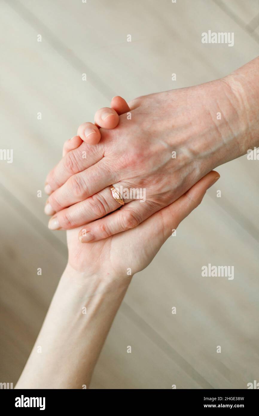 Hand of young girl holds hand of elderly mother. Older generation ...