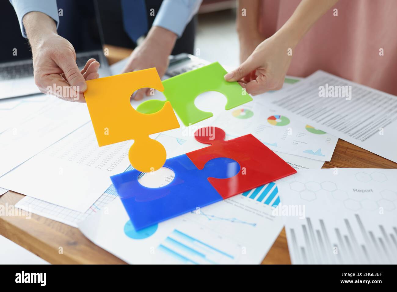 Coworkers solving jigsaw puzzle on workplace, colourful parts Stock ...