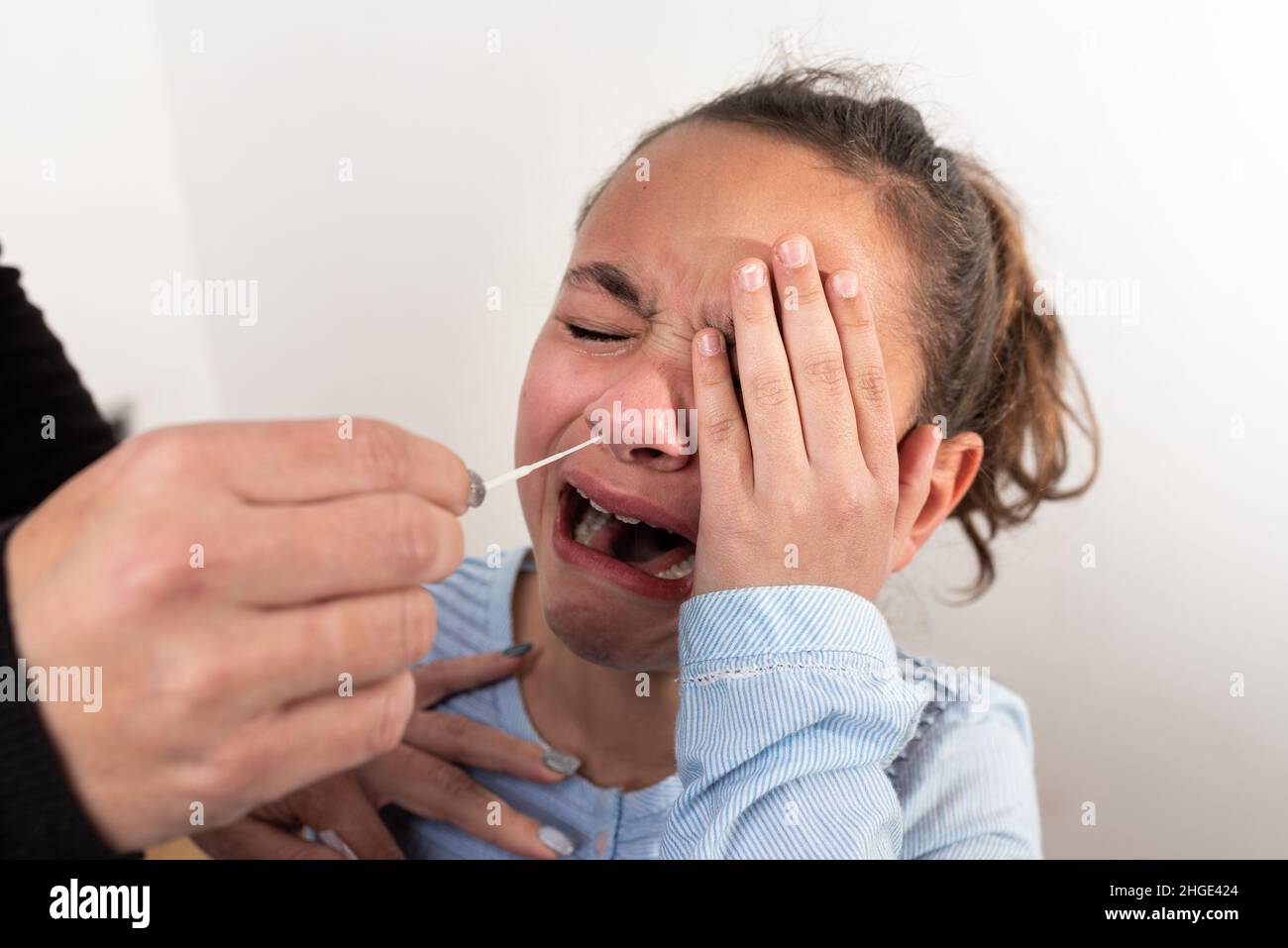 Little girl crying while getting a rapid COVID-19 test at home Stock ...