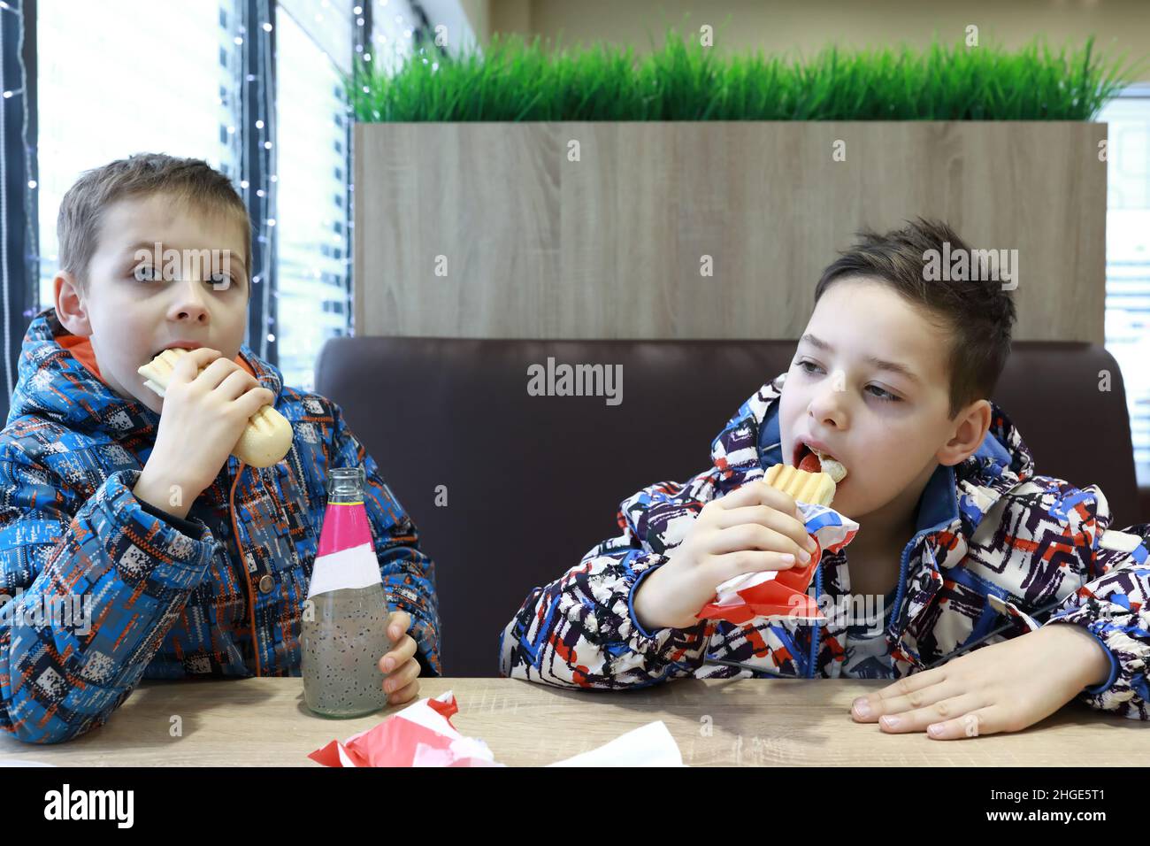 Portrait of children eating hot dogs in cafe at gas station Stock Photo ...
