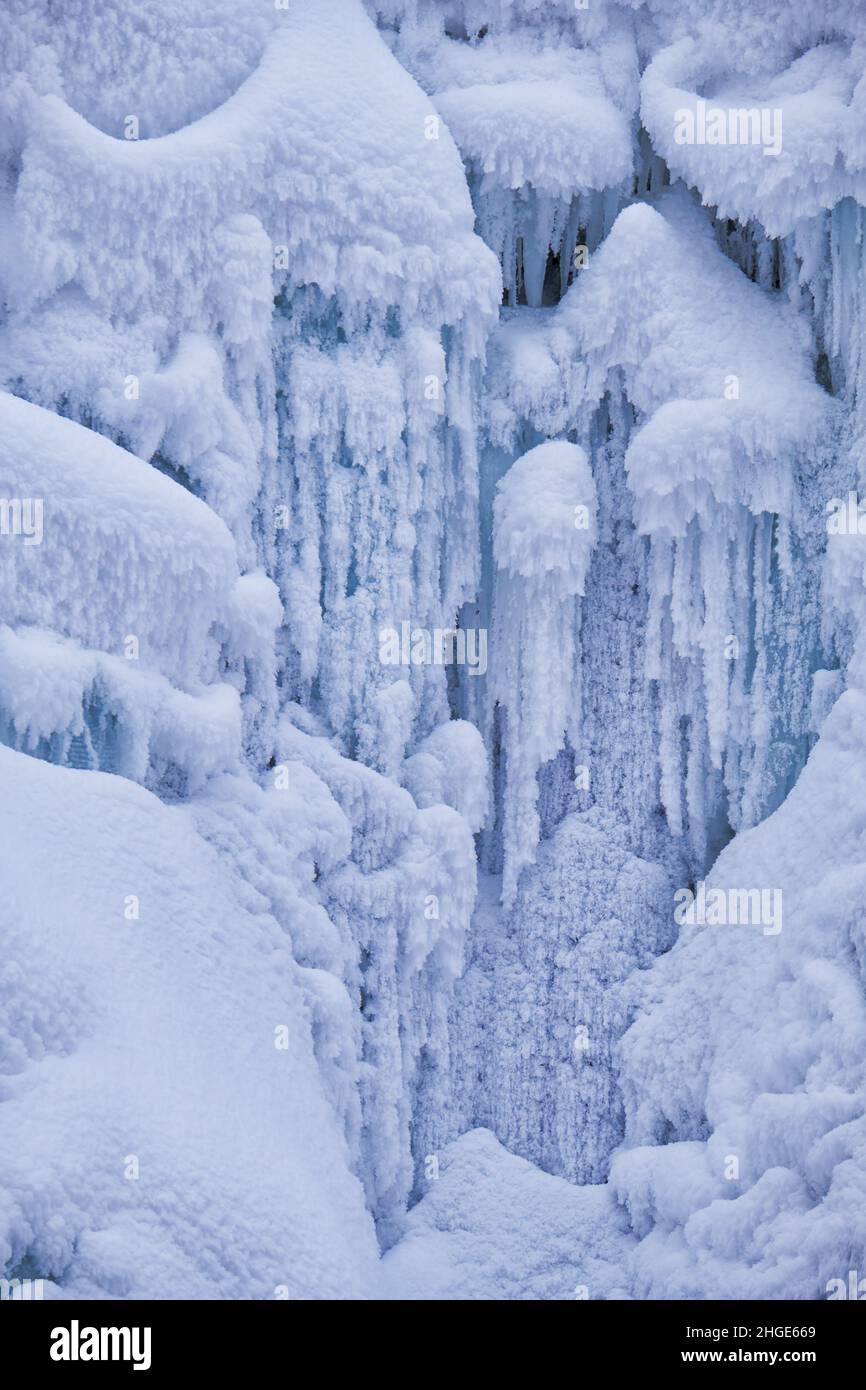 Photo of icicles Stones with snow caps and ice in the water of frozen ...