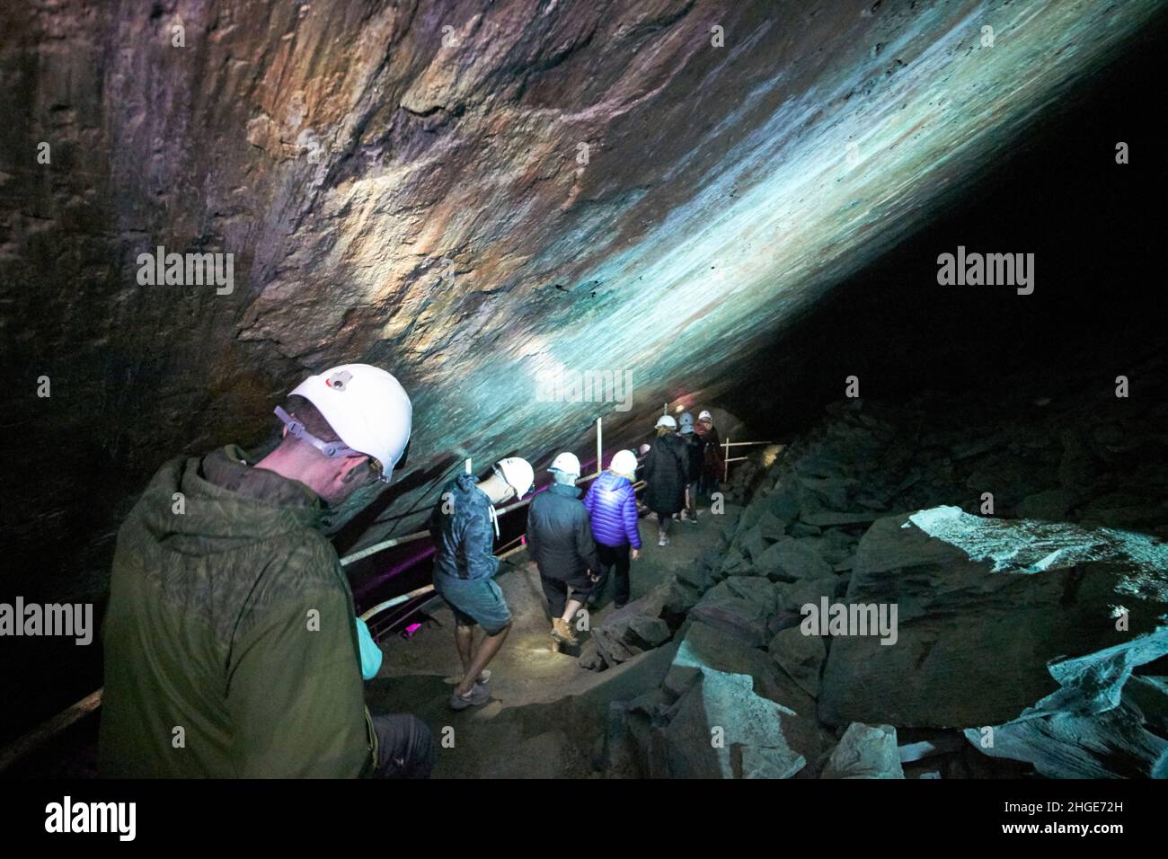 tourists on guided tour walk down steep steps inside the honister slate ...