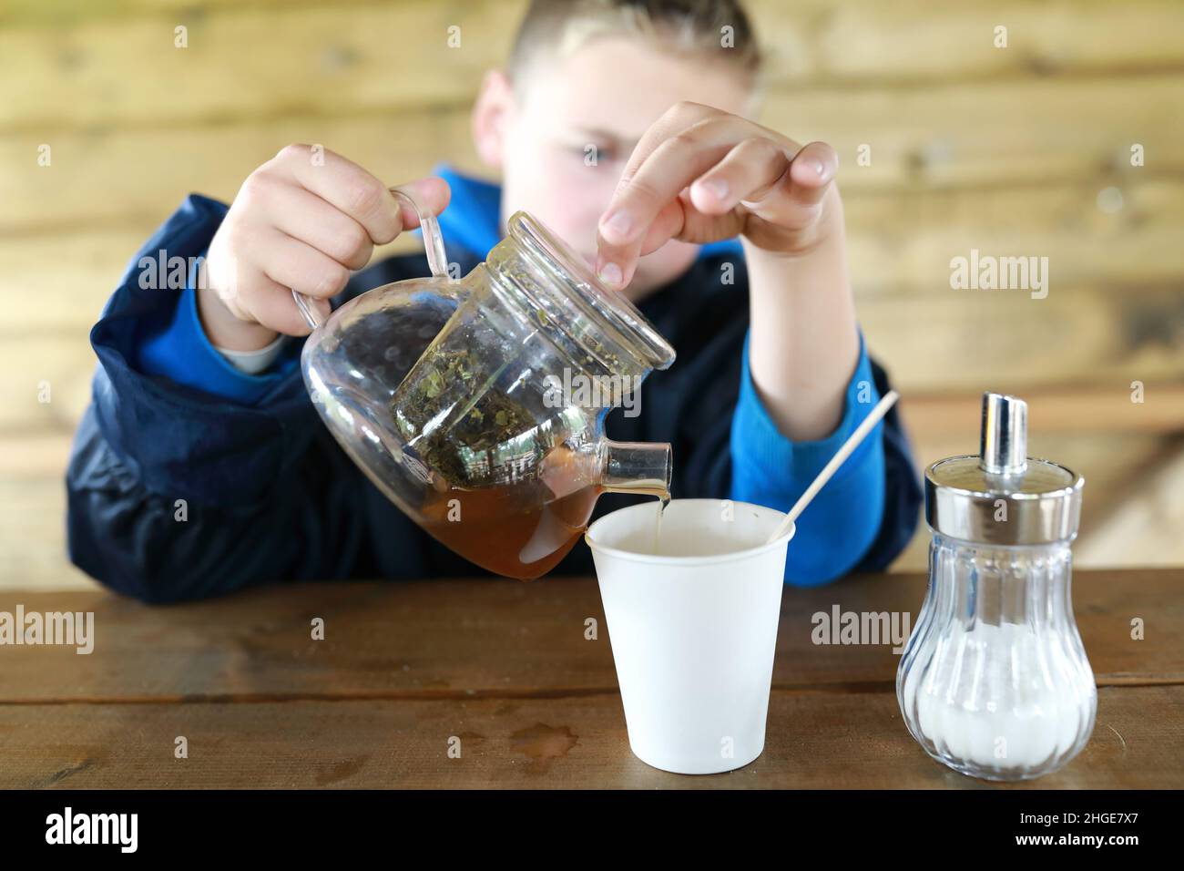 Kid pouring herbal tea on restaurant terrace Stock Photo - Alamy
