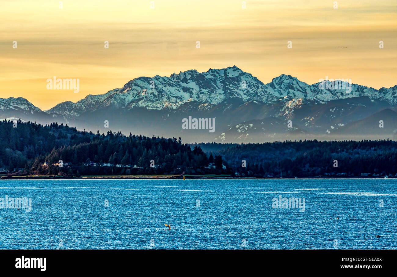 A sunset with the Olympic Mountains across the Puget Sound Stock Photo ...