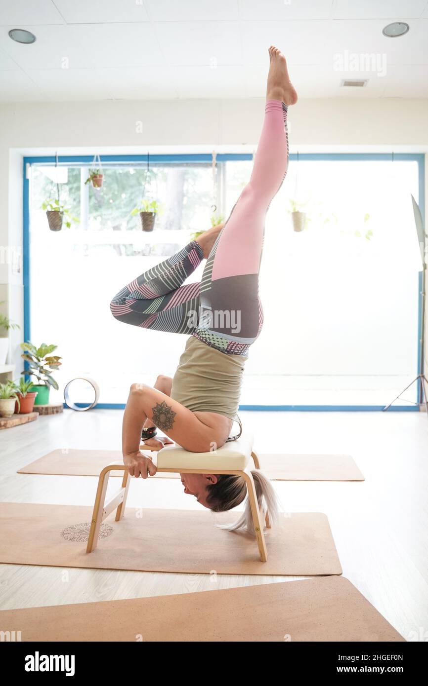 Portrait of a young yogi practising yoga, wearing sports clothes, in a ...