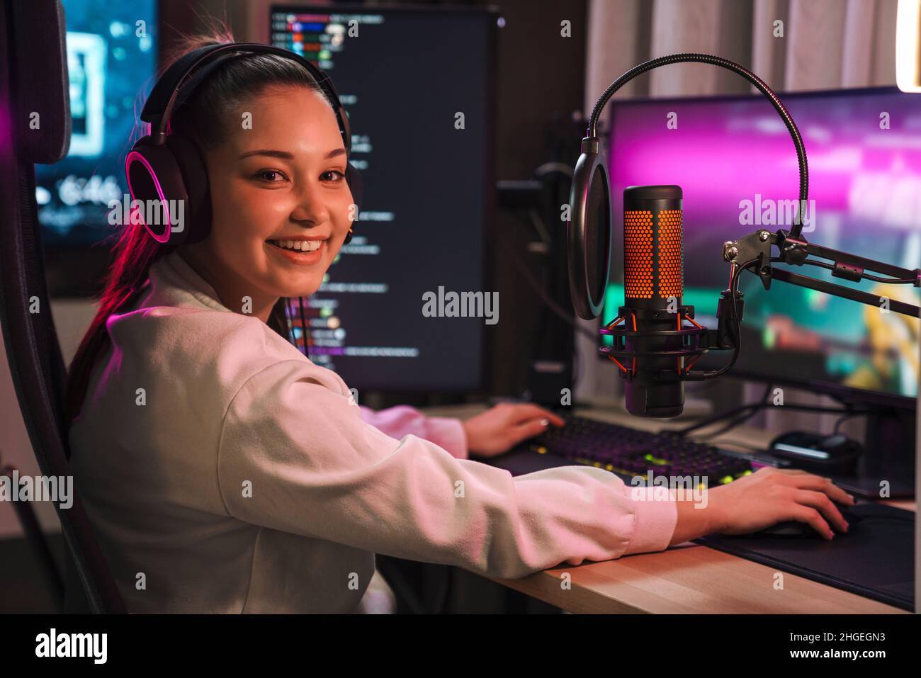 Happy young woman streamer gamer in headphones playing online games on ...