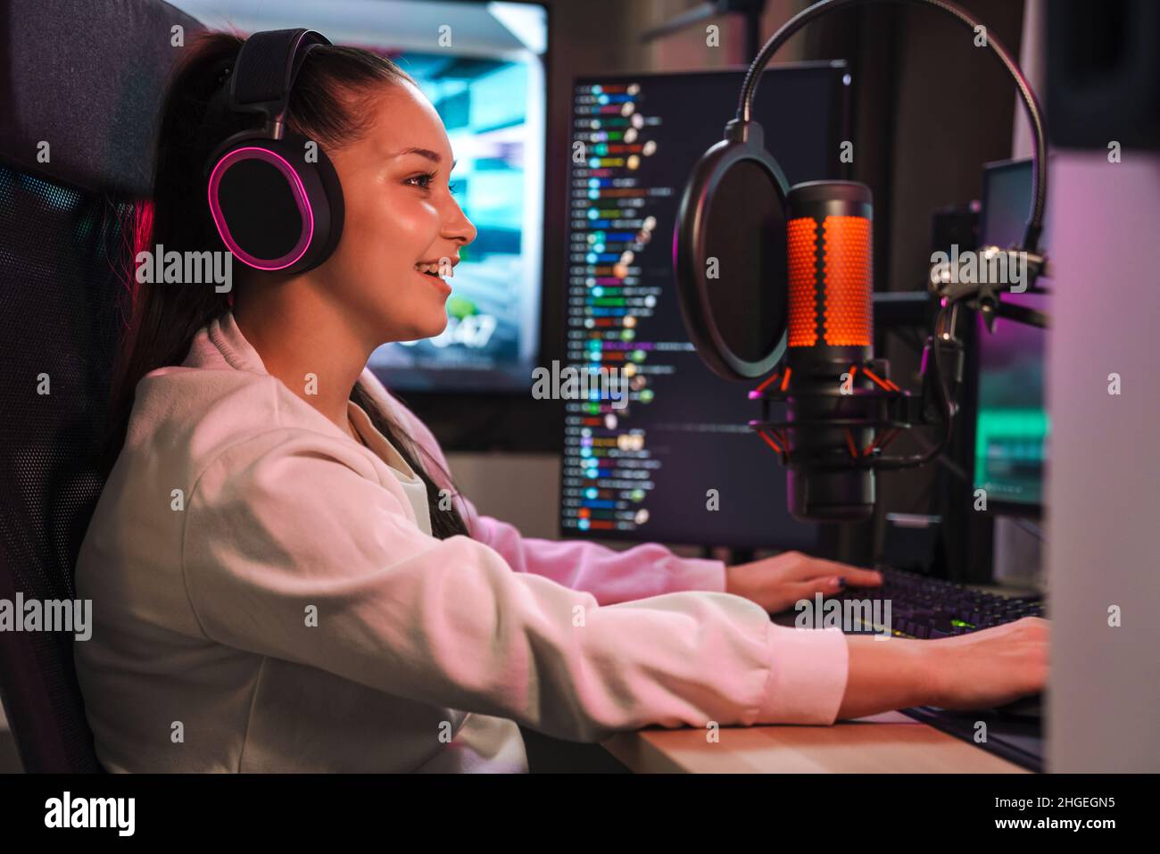 Happy young woman streamer gamer in headphones playing online games on ...