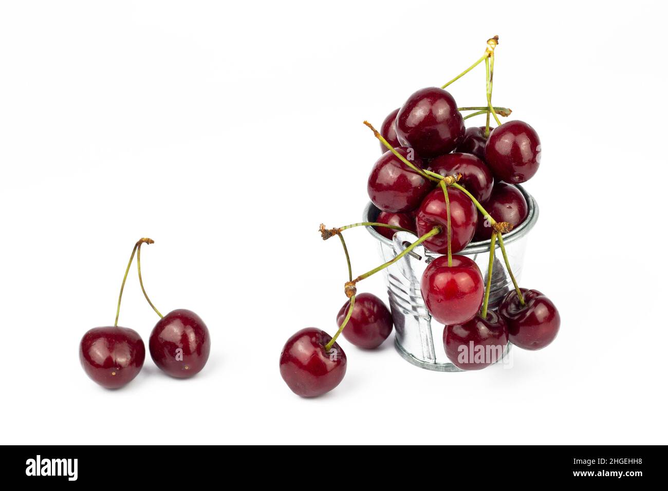 Ripe cherry in small metal bucket on white background Stock Photo - Alamy