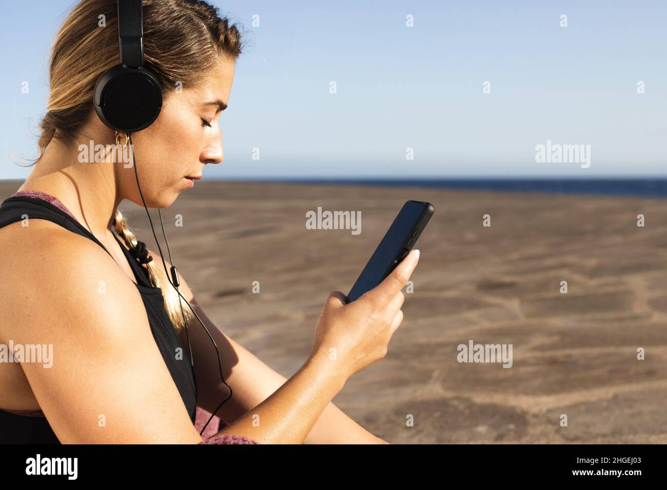 Young woman stretching while reading smartphone Stock Photo - Alamy