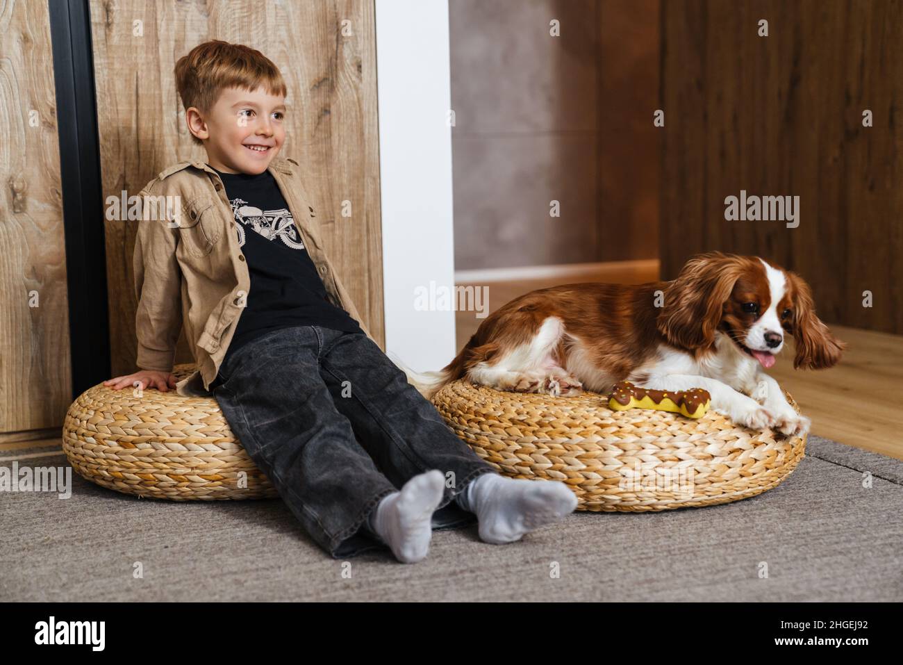 Happy little kid playing with his dog at home on a floor Stock Photo ...