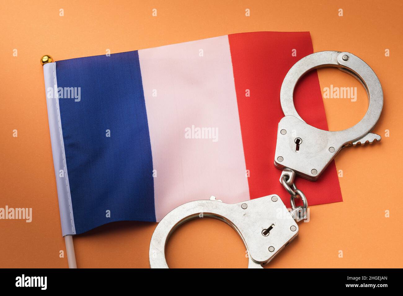 French flag and handcuffs on a colored background, a concept on the ...