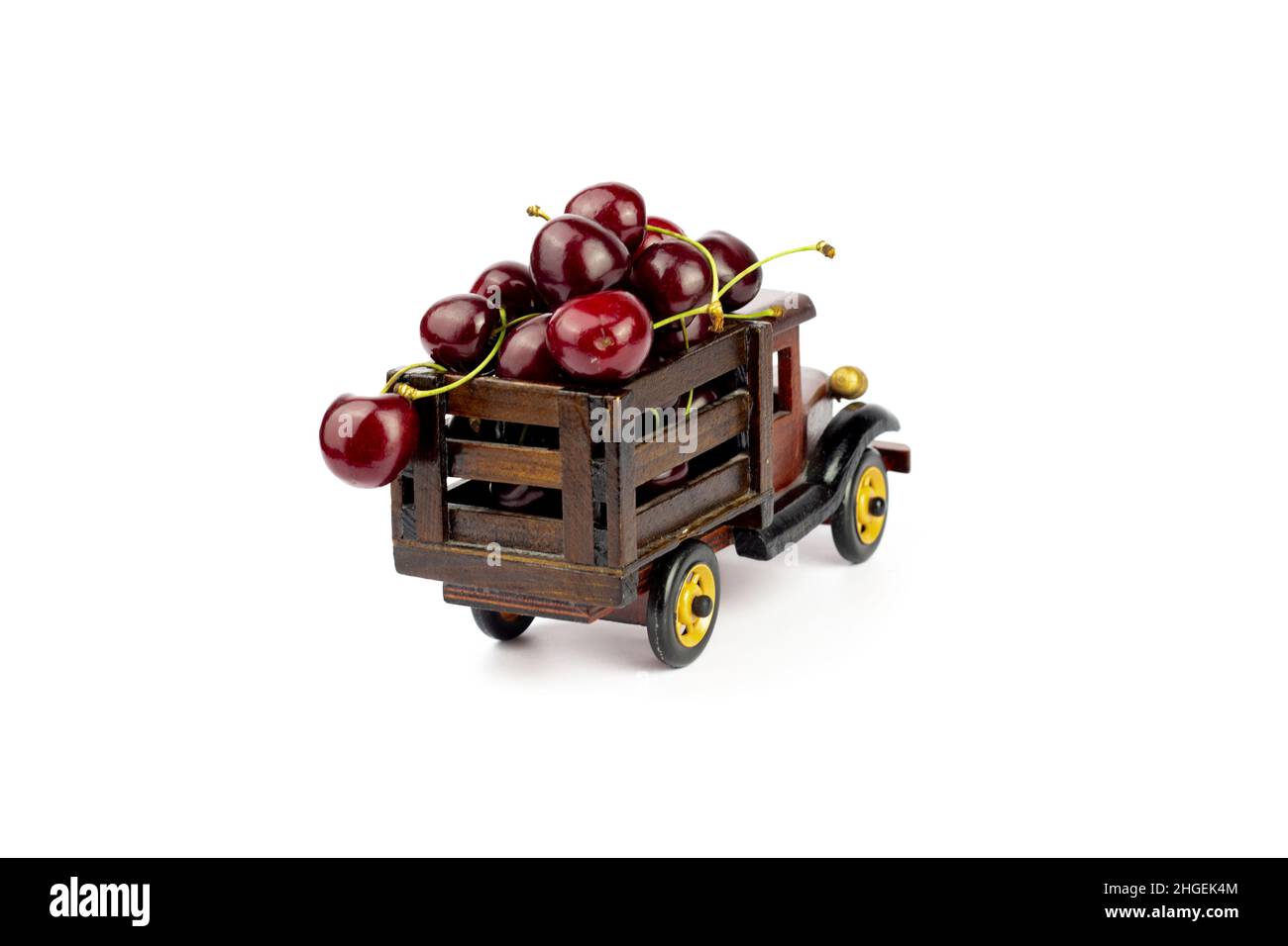 Ripe sweet cherries in a wooden toy truck on white background Stock ...