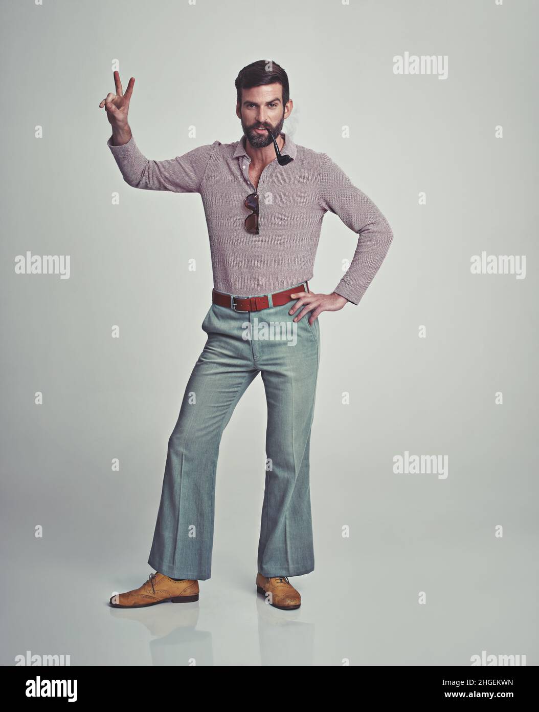 Peace out. Studio shot of a handsome man striking a pose while wearing ...