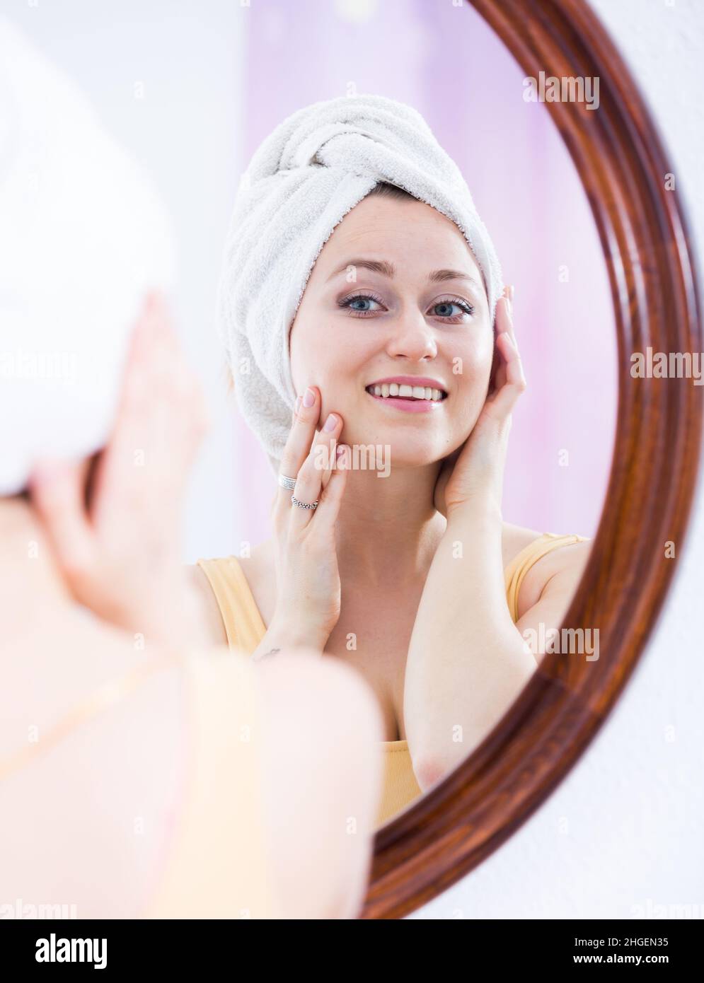 Young woman mirror face inspecting hi-res stock photography and images ...