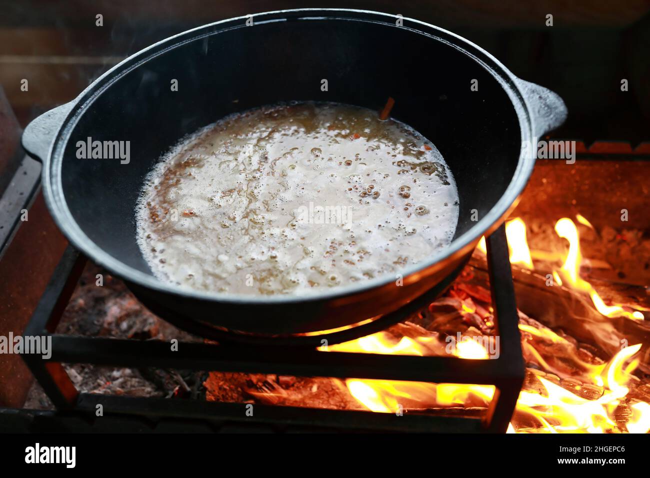 Cooking buckwheat porridge with stewed meat in cauldron on fire Stock ...