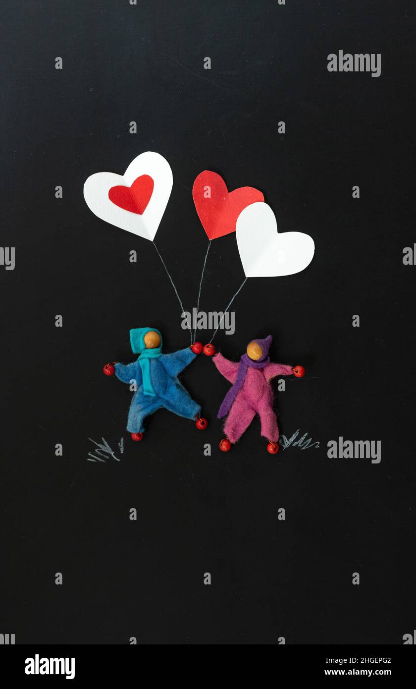 2 gender neutral characters holding heart balloons on a chalkboard ...