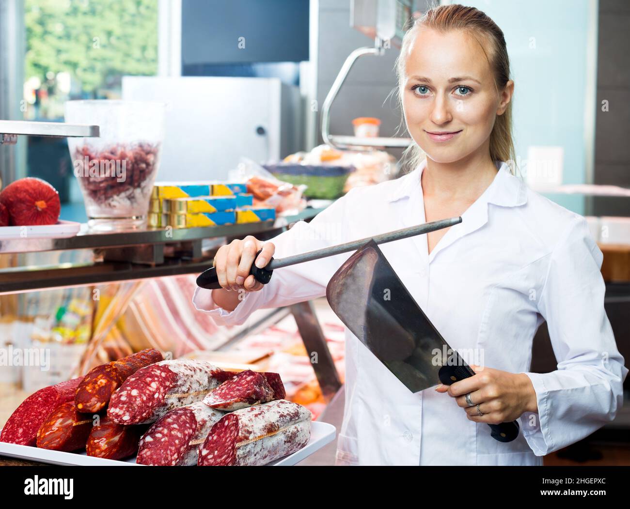 Female seller wearing uniform working with fresh meat Stock Photo - Alamy