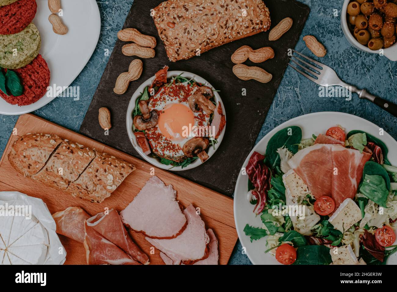Lots of food and dishes in the background. Meat platter and Camembert ...