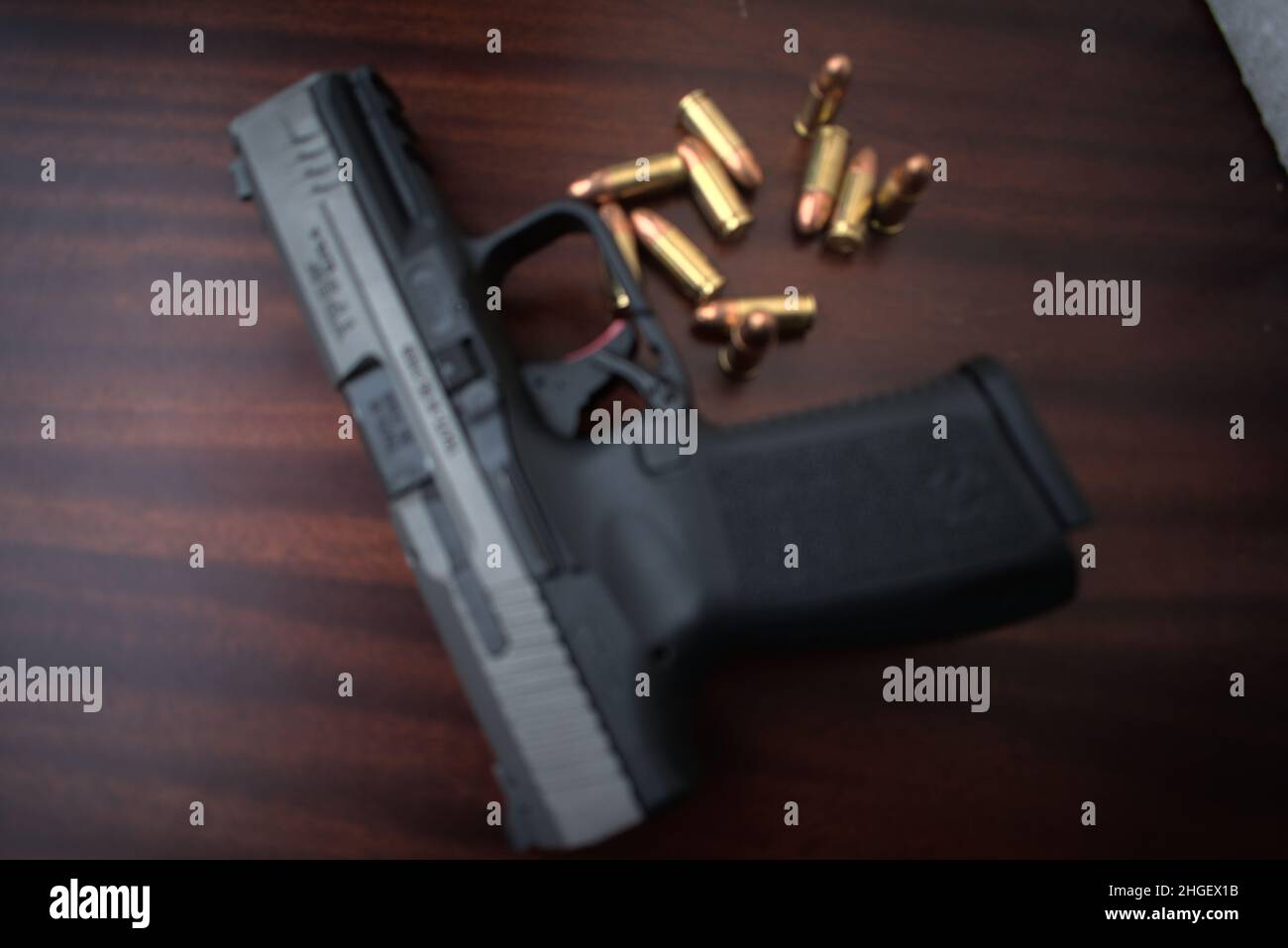 A blurred handgun and blurred bullets on a brown background Stock Photo ...