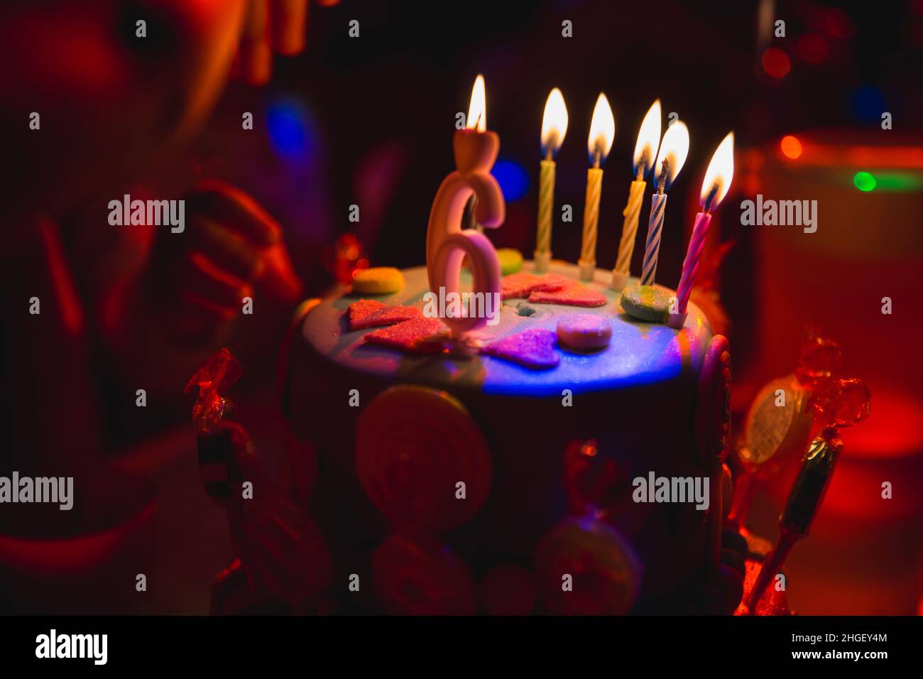 Birthday multicolored cake with burning candles and age 6 candle in the ...