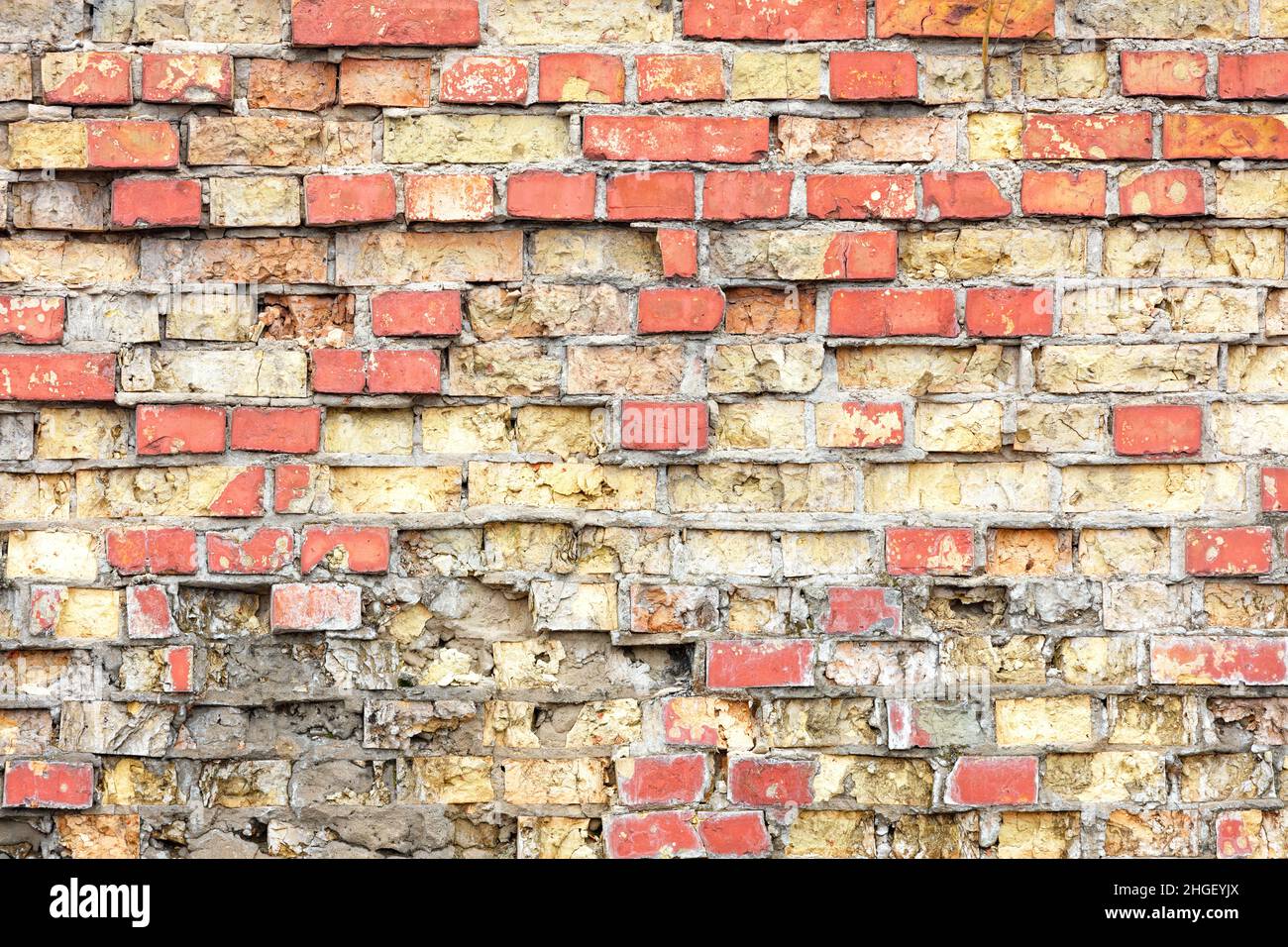 Texture of an old red brick wall with numerous damages and debris of ...