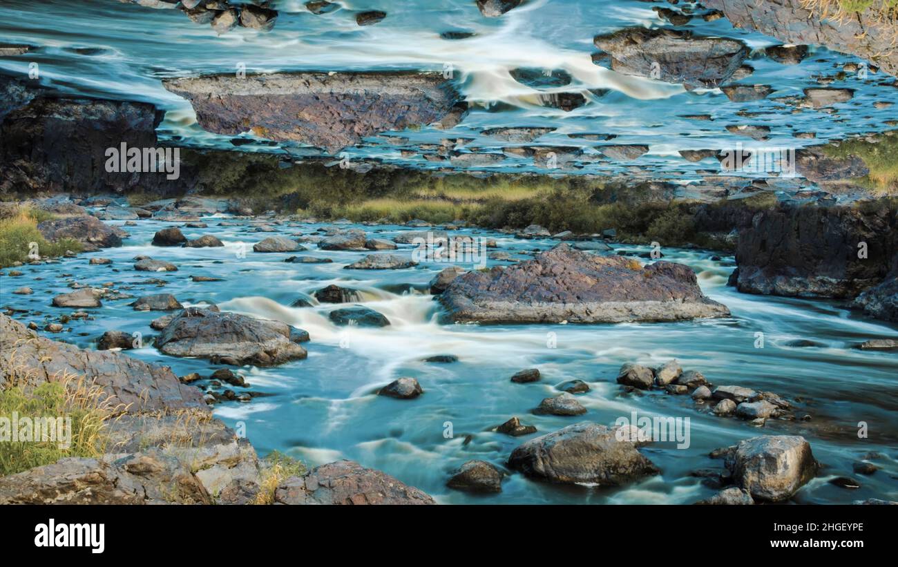 Amazing turquoise water stream with stones and mirror horizon effect ...