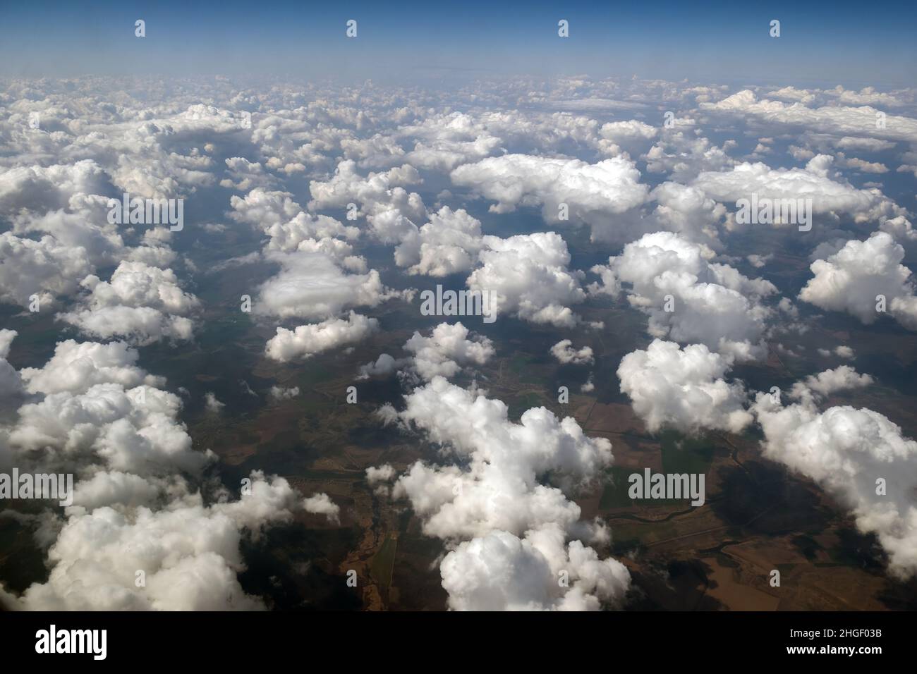 Aerial view from airplane window of white puffy clouds on bright sunny ...
