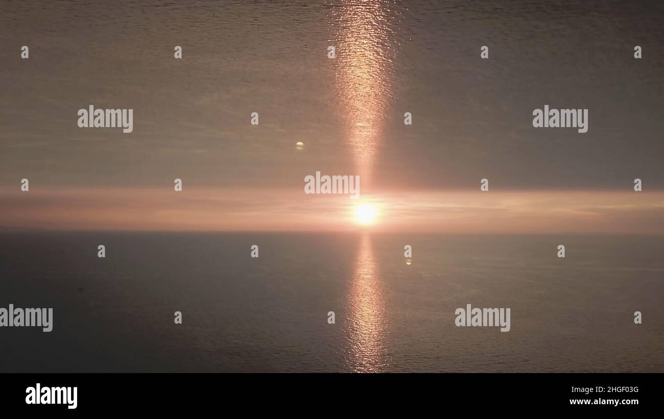 Beautiful sunset in the sea with a mirror horizon effect. Evening sun ...