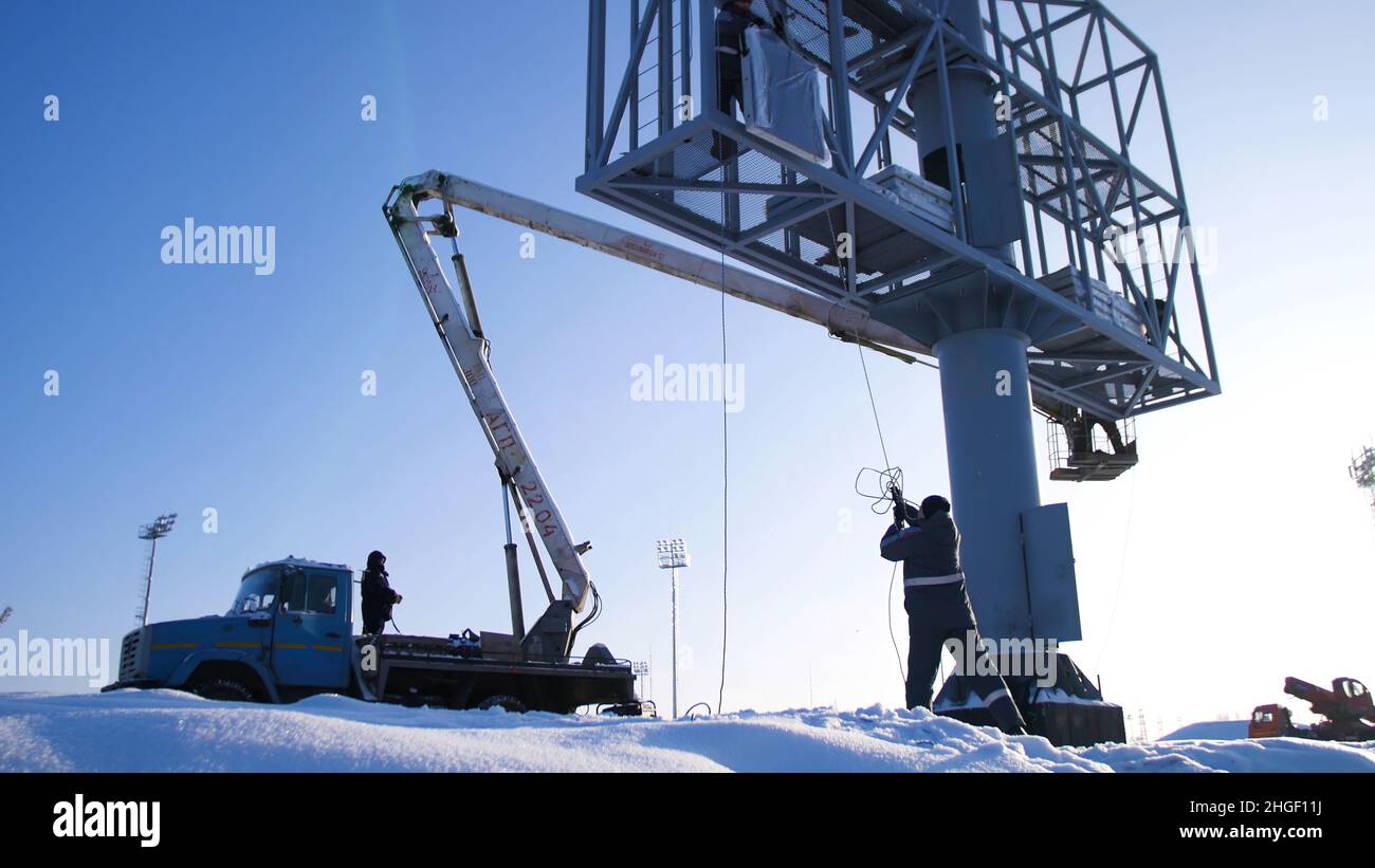 Men assemble Billboard on tap. Builder on a Lift Platform at a ...