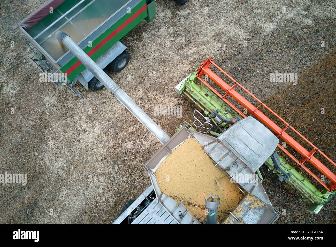 Aerial view of combine harvester unloading grain in cargo trailer ...