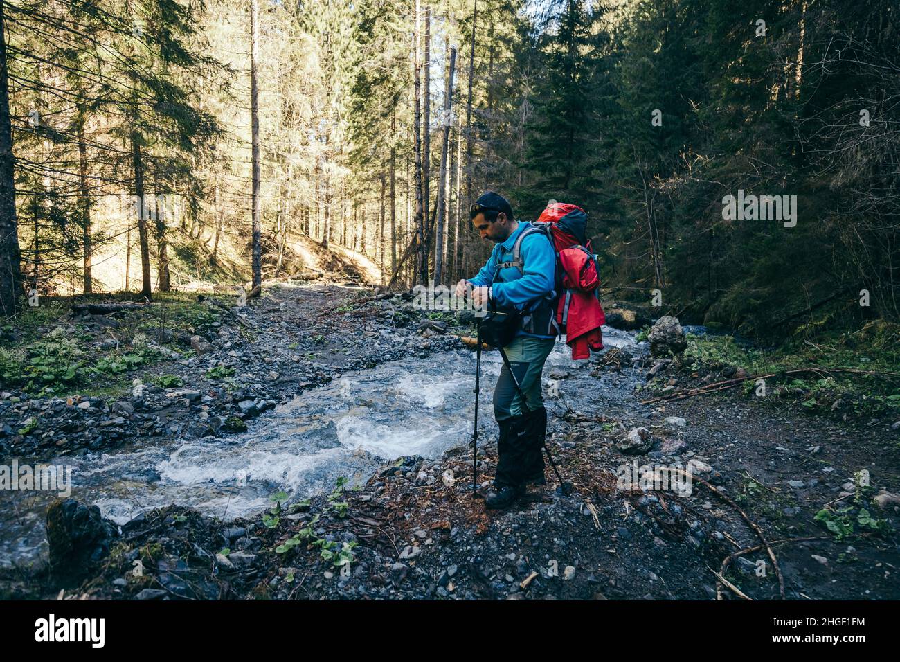 River in the mountains with stones, a tourist crosses the river Stock ...